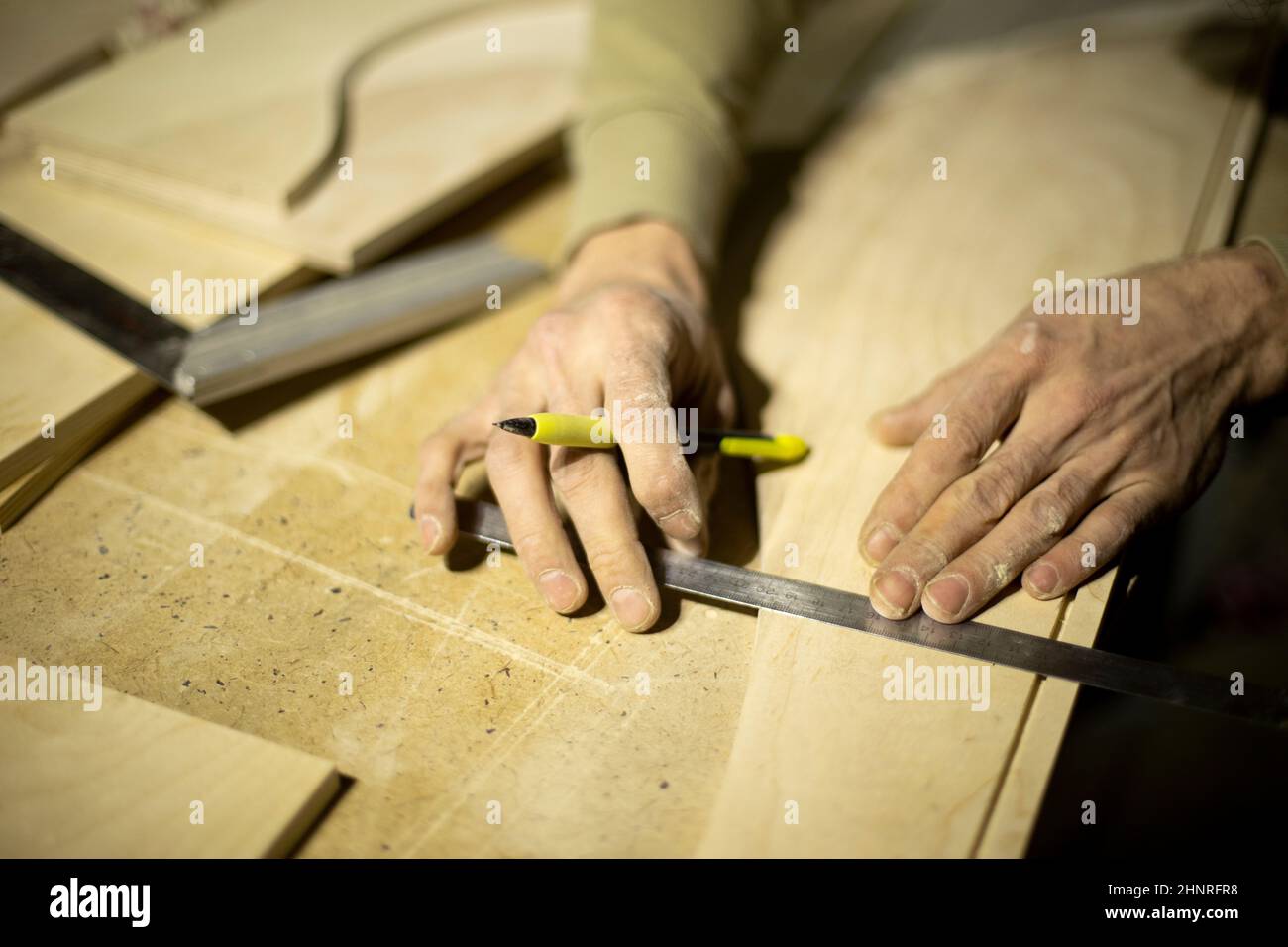 Guy marks board on ruler. Marking with pencil Stock Photo - Alamy