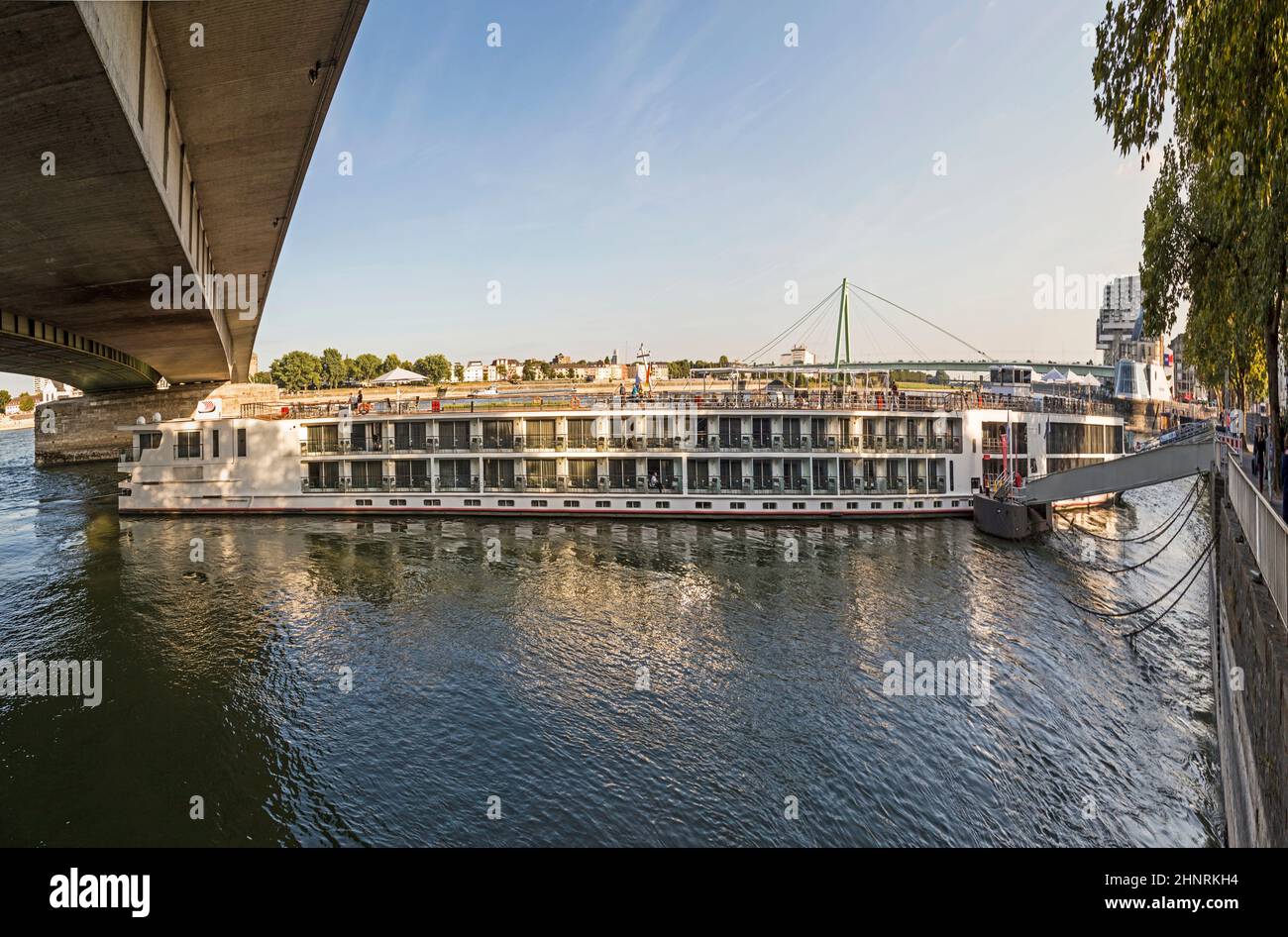 skyline of Cologne with river Rhine in late afternoon and cruise ship ...