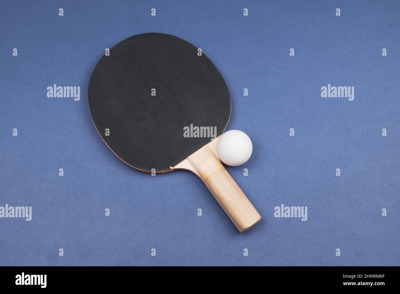Black ping pong racket with a ball isolated on a color background ...