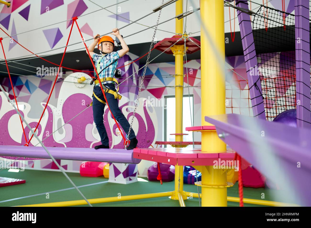 Cheerful little boy on zip line in entertainment center. Children ...