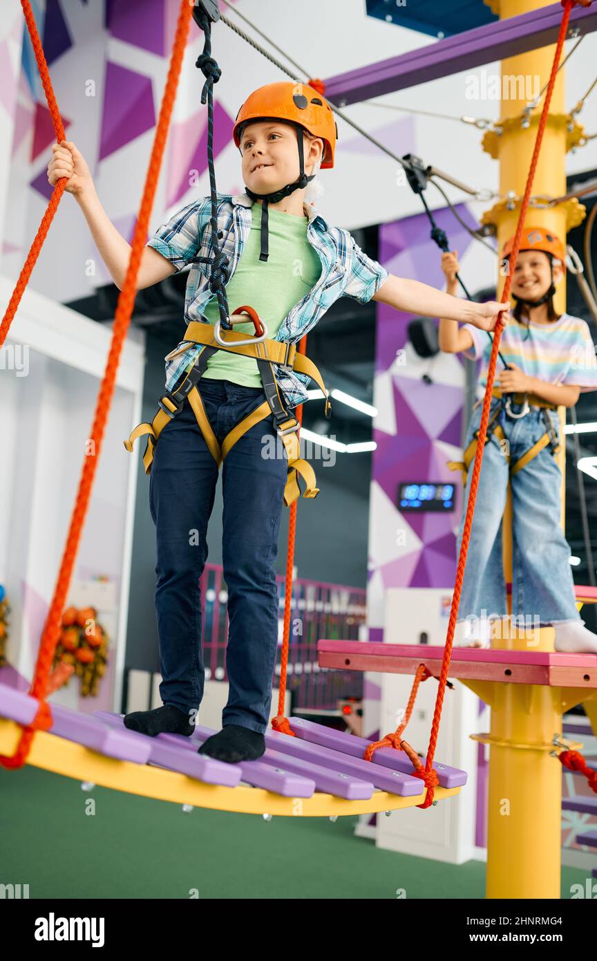 Cheerful children on zip line in entertainment center. Boy and girl ...