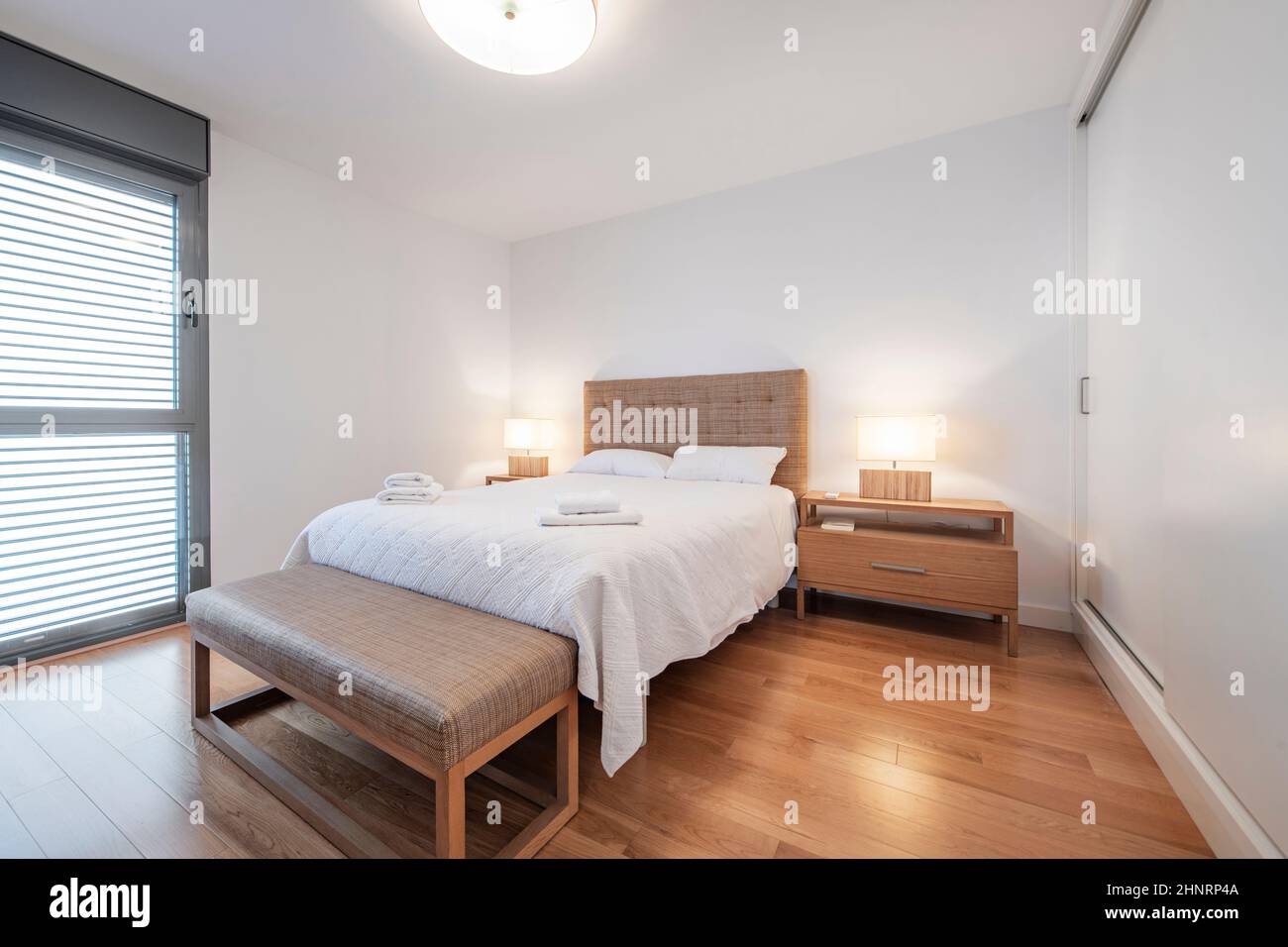 Bedroom with upholstered headboard with quilted fabric, matching wooden ...