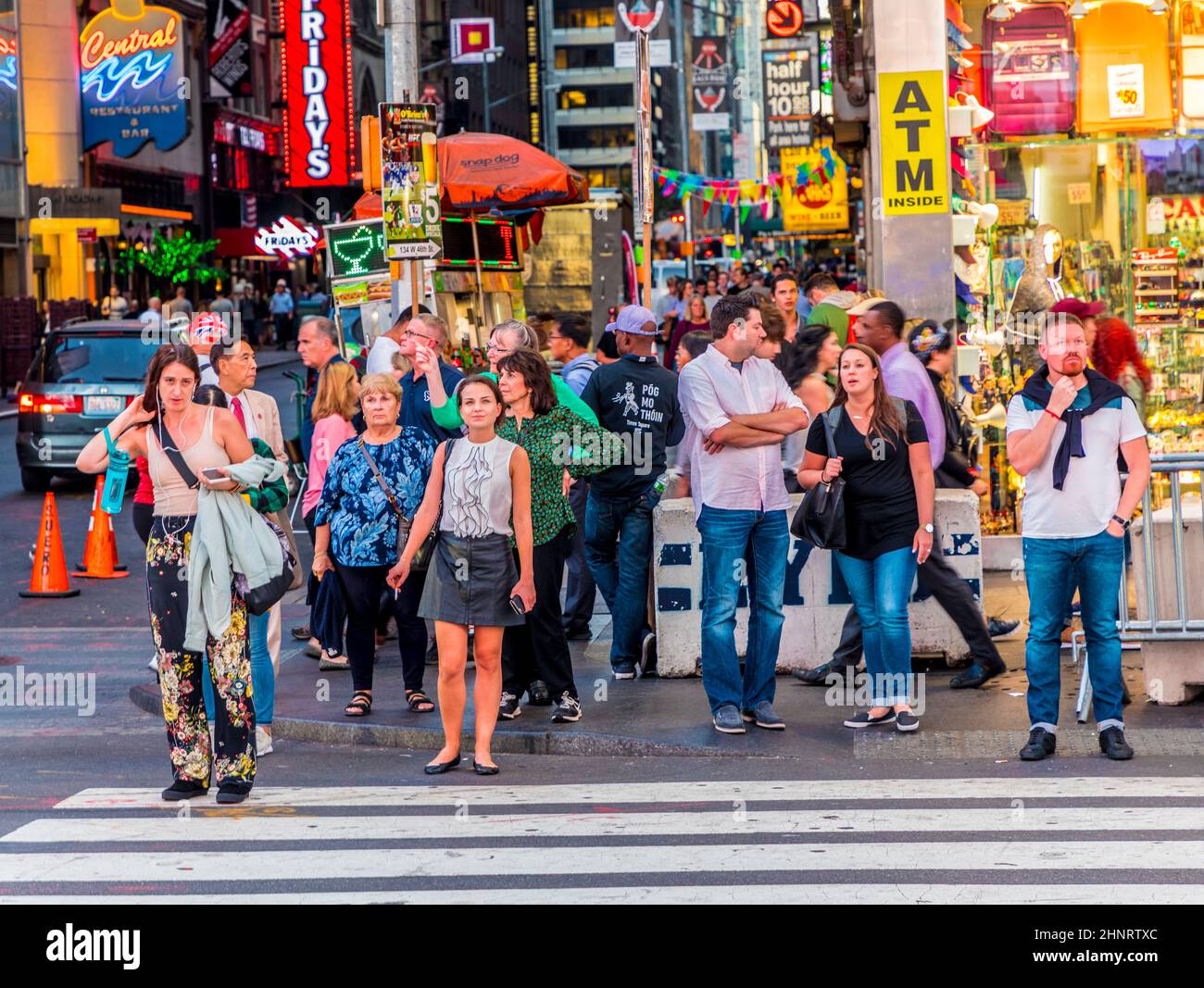 people wait at a pedestrian crossing at times square in late afternoon ...