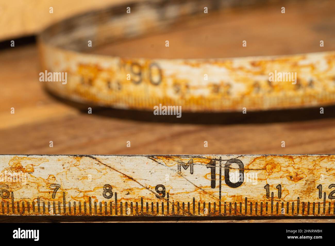 Old rusty ruler with black numbers on a working wooden table. vintage ...