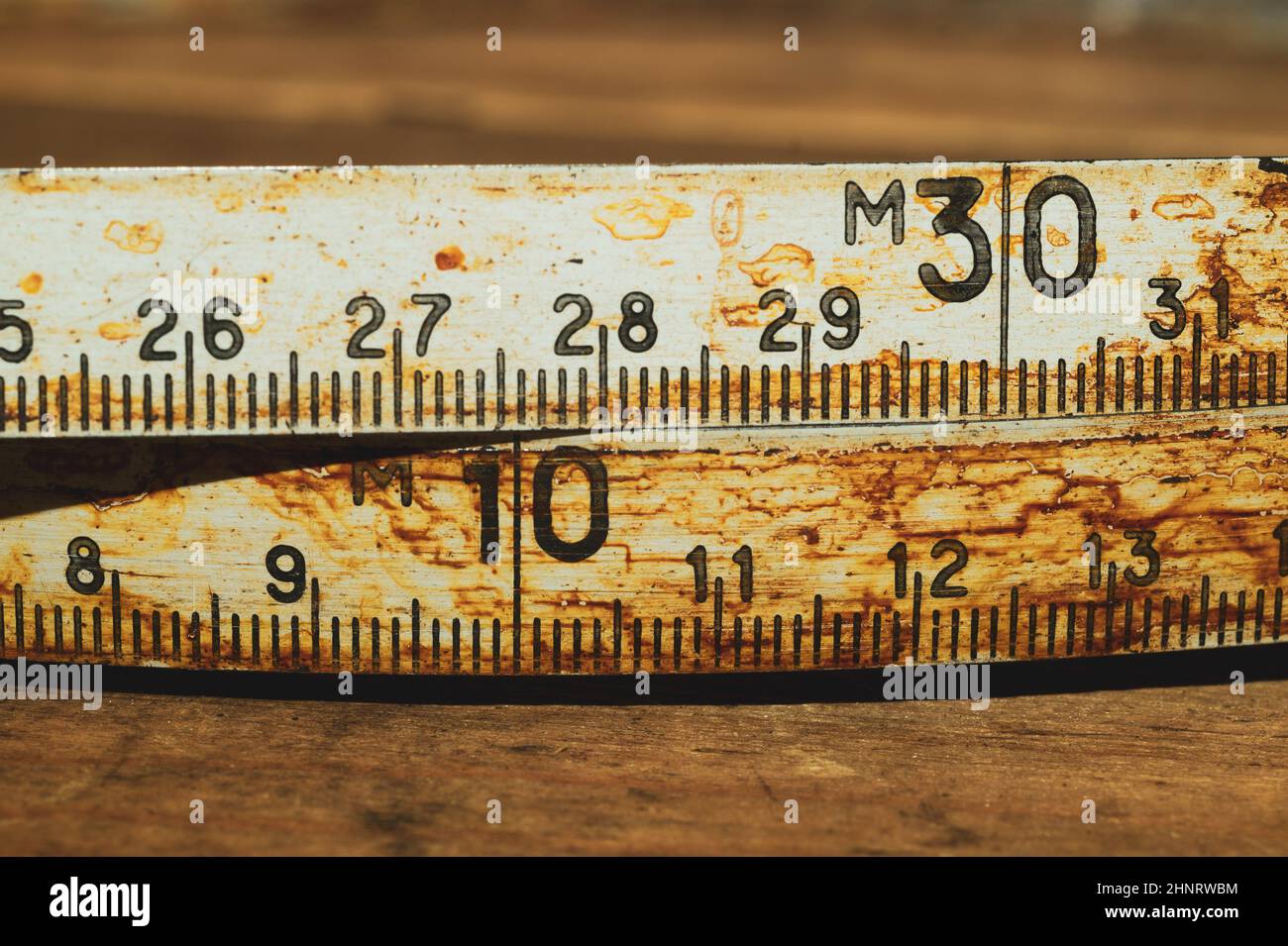 Old rusty ruler with black numbers on a working wooden table. vintage ...