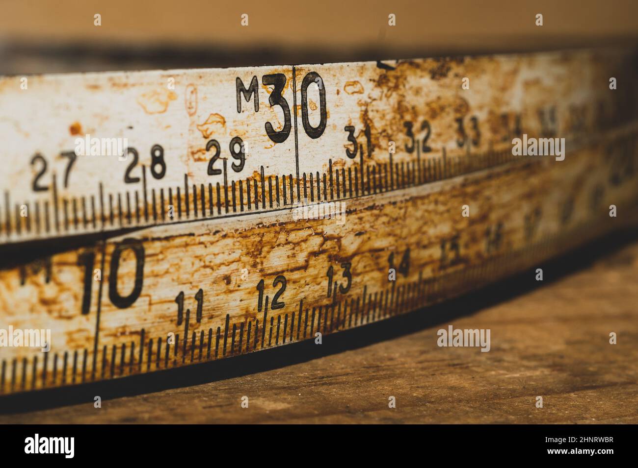 Old rusty ruler with black numbers on a working wooden table. vintage ...