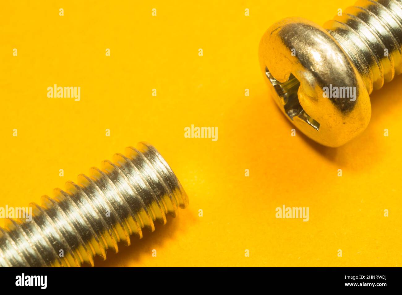 Steel screw on a yellow background. working tools Stock Photo - Alamy