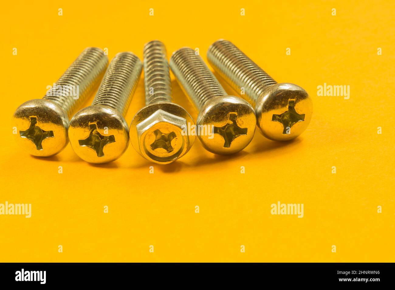 Steel screw on a yellow background. working tools Stock Photo - Alamy