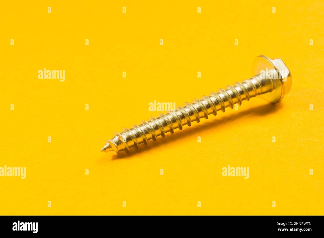 Steel screw on a yellow background. working tools Stock Photo - Alamy