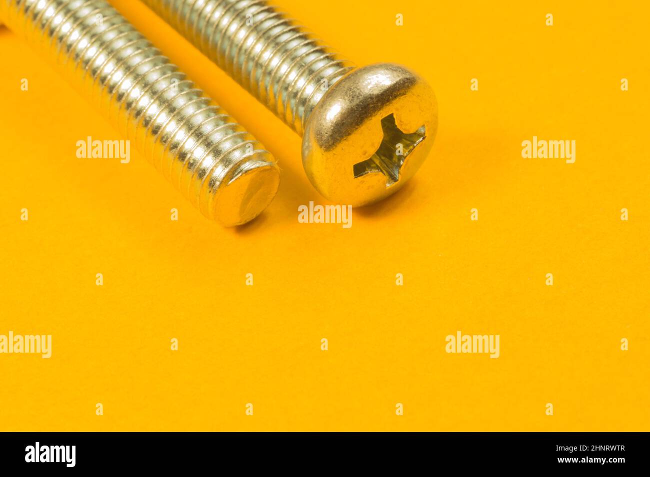 Steel screw on a yellow background. working tools Stock Photo - Alamy