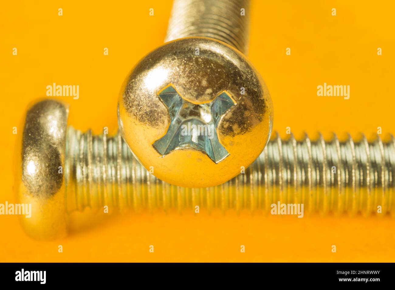 Steel screw on a yellow background. working tools Stock Photo - Alamy