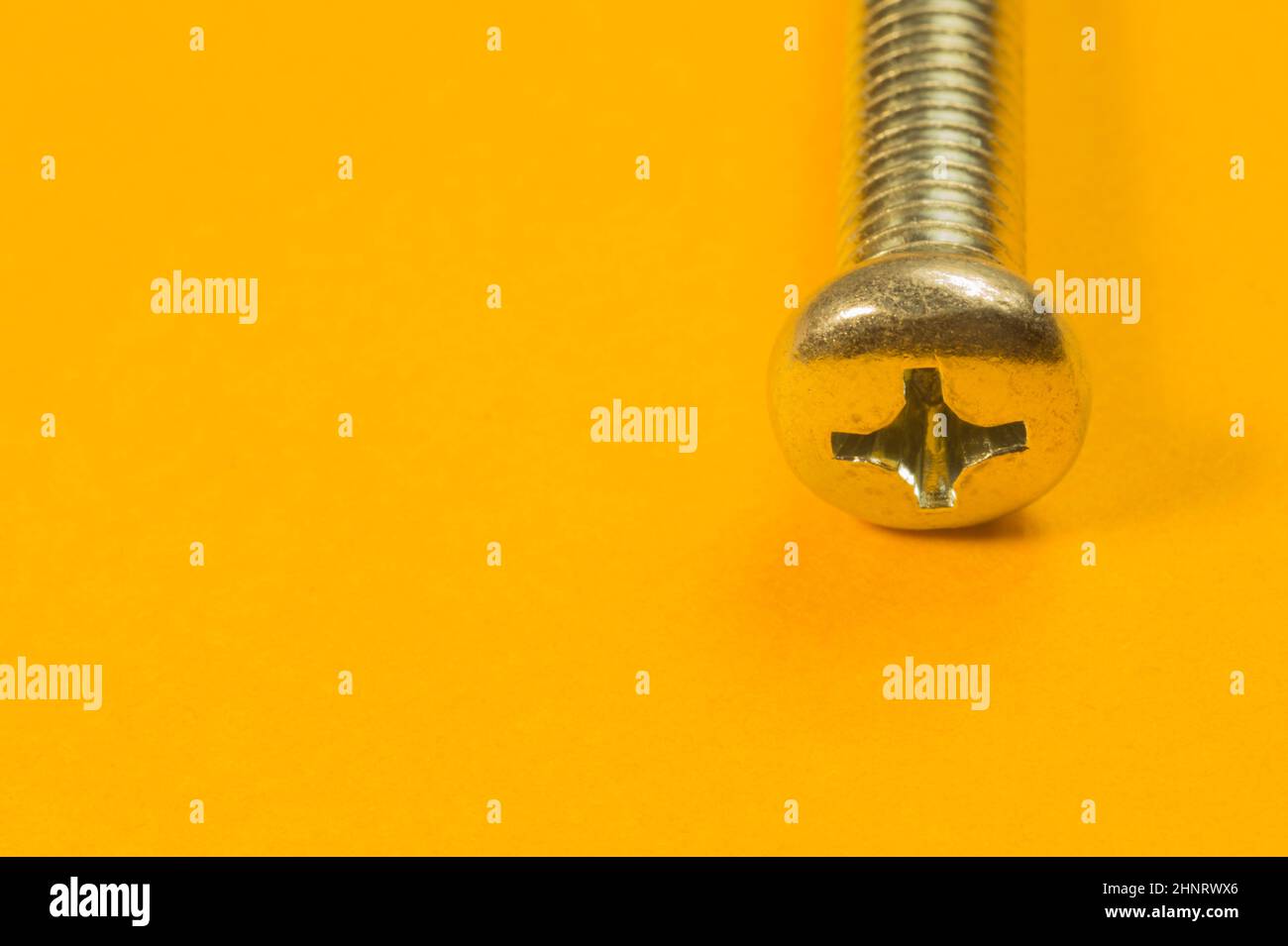 Steel screw on a yellow background. working tools Stock Photo - Alamy