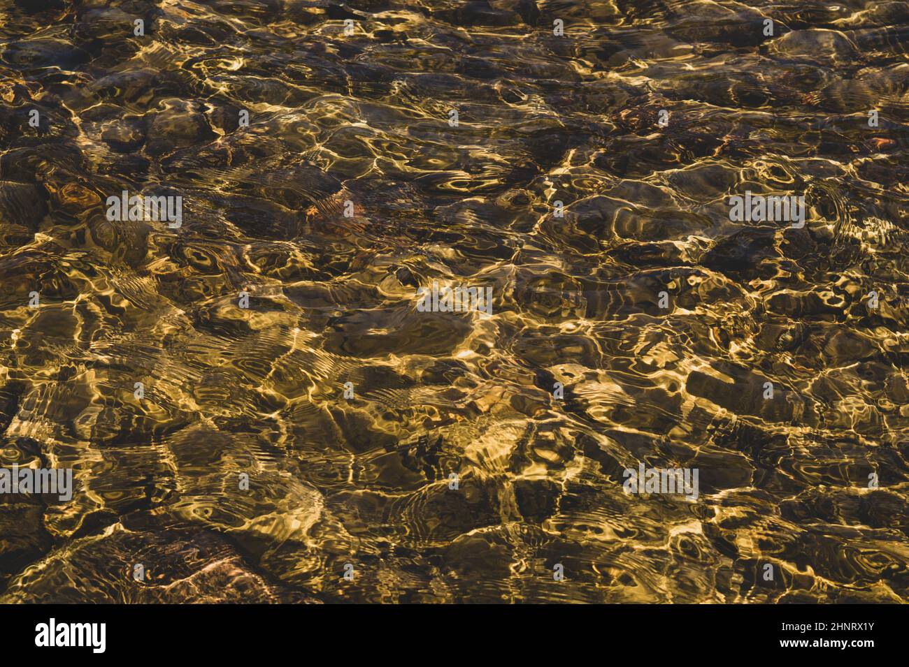 Shiny transparent water. clear water with pebbles and stone on the ...