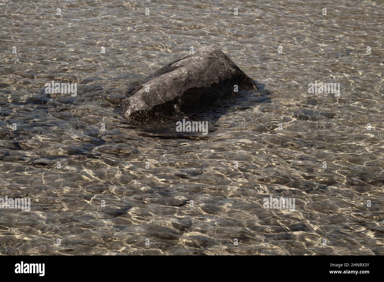 Shiny transparent water. clear water with pebbles and stone on the ...
