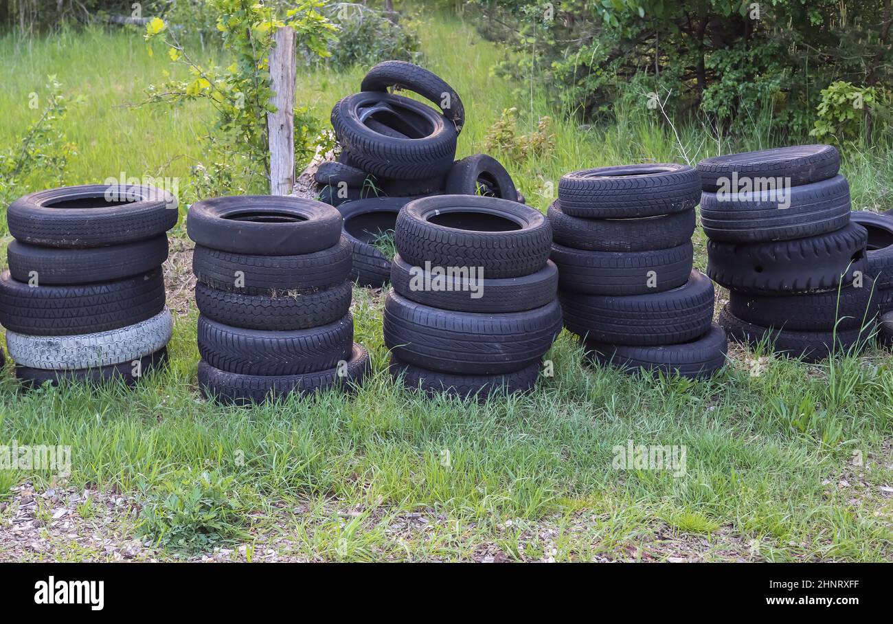 Damaged and worn old black tires on a stack. Tire tread problems ...