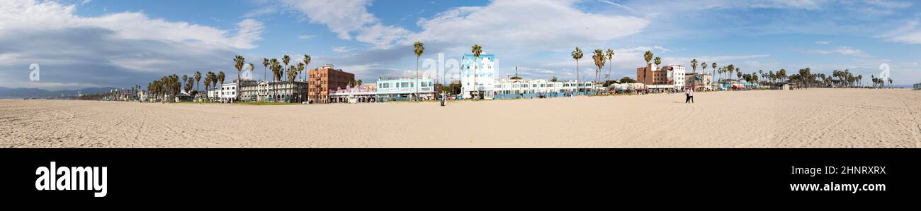 people enjoy scenic beach promenade with palms and colorful houses at ...