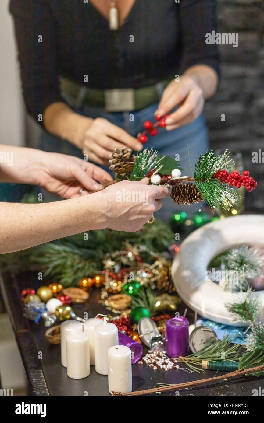 Two women are preparing advent wreath and Christmas decorations ...