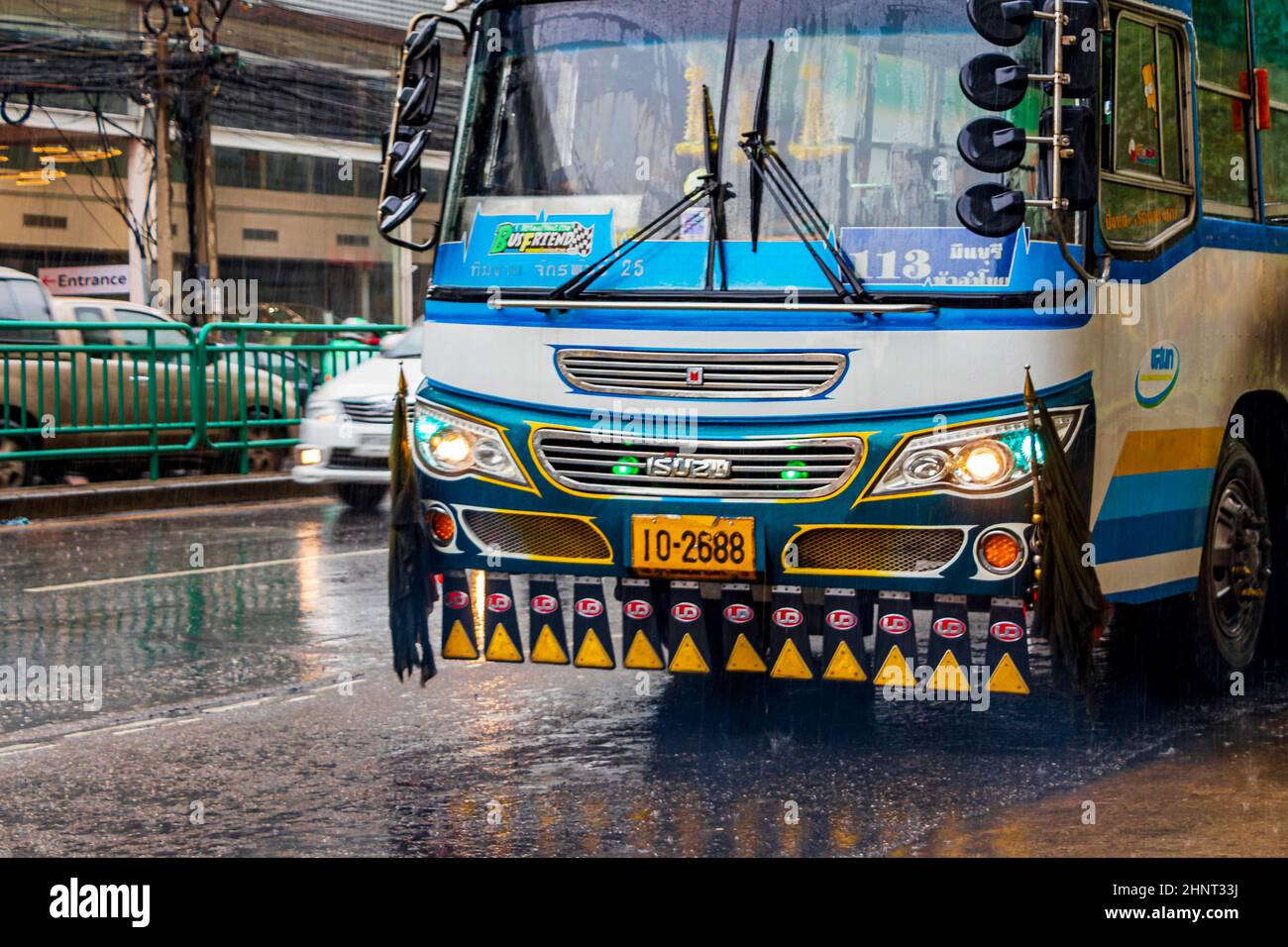 Typical colorful blue decorated bus in heavy rain Bangkok Thailand ...