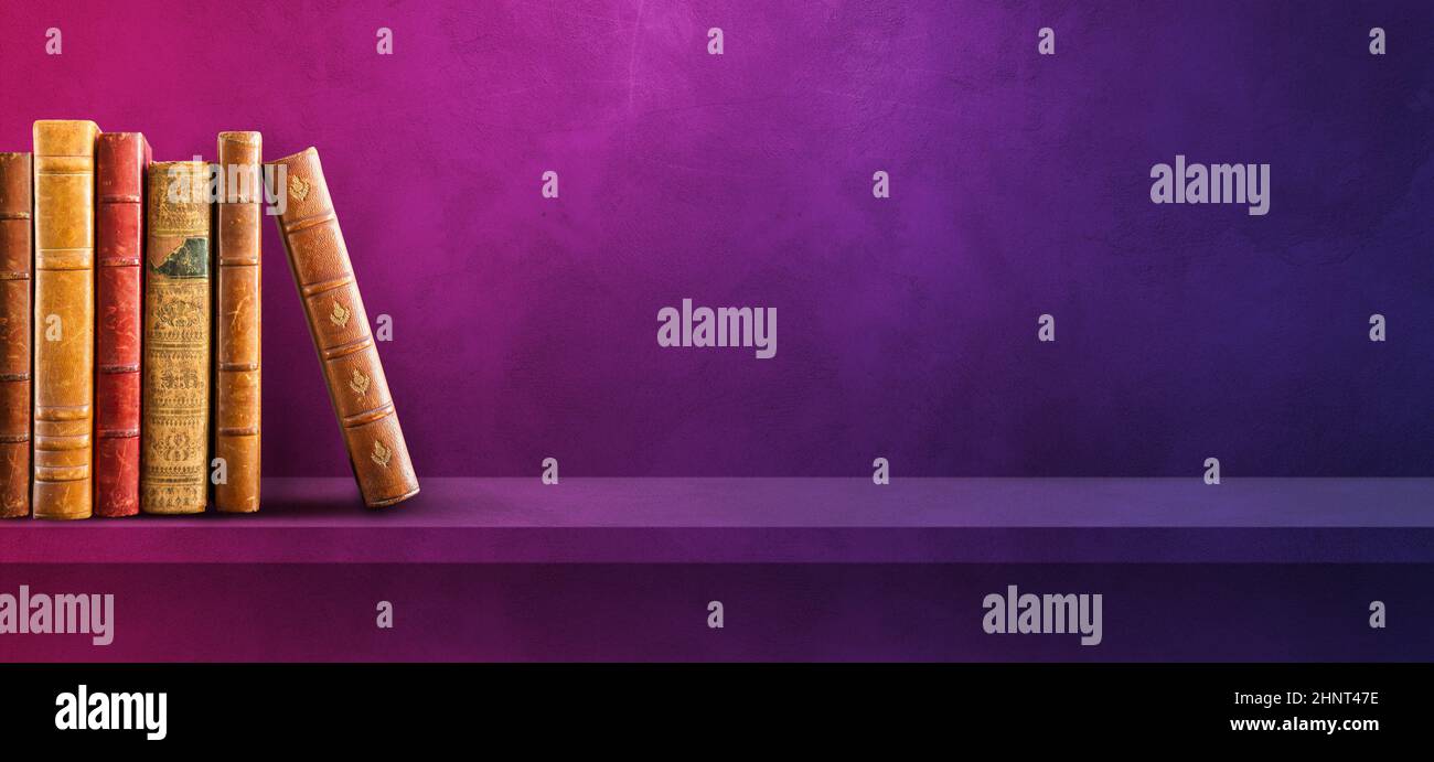 Row of old books on purple shelf. Background banner Stock Photo - Alamy