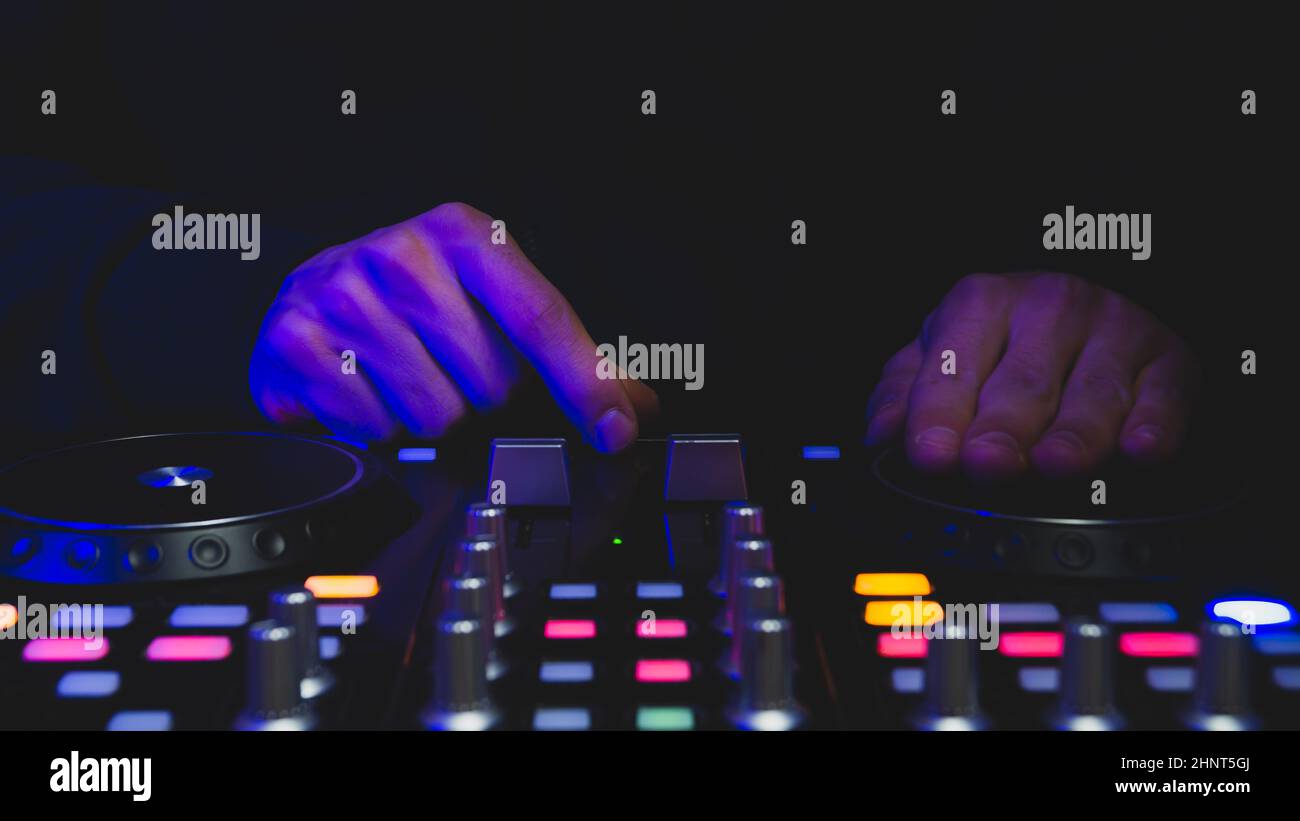 DJ plays music. sound mixer controller with knobs and sliders close up ...