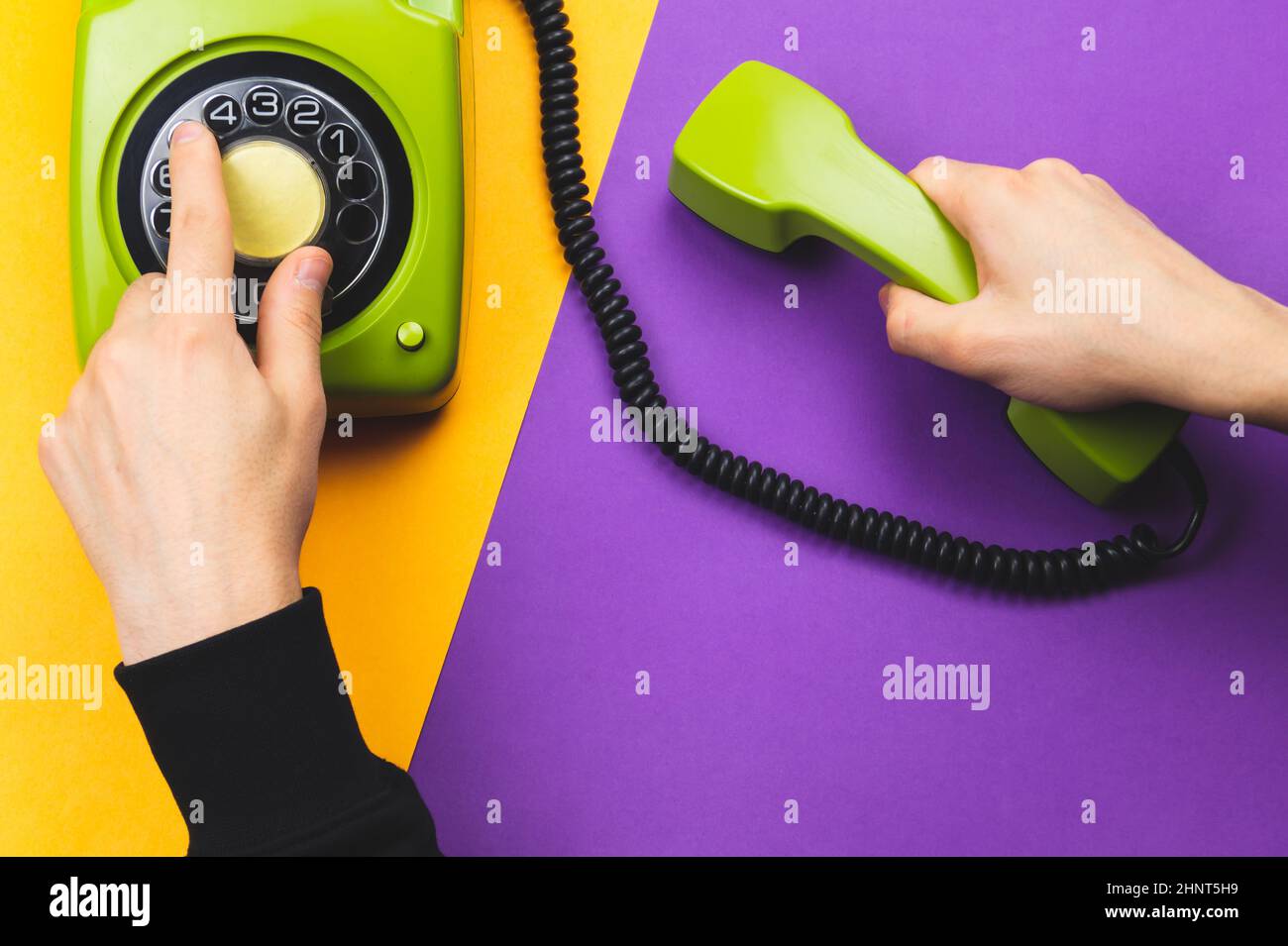 Hand dialing a number on a classic phone with round dial. vintage green ...