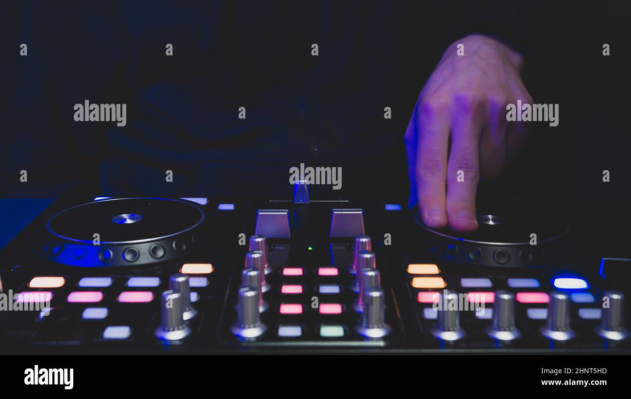 DJ plays music. sound mixer controller with knobs and sliders close up ...