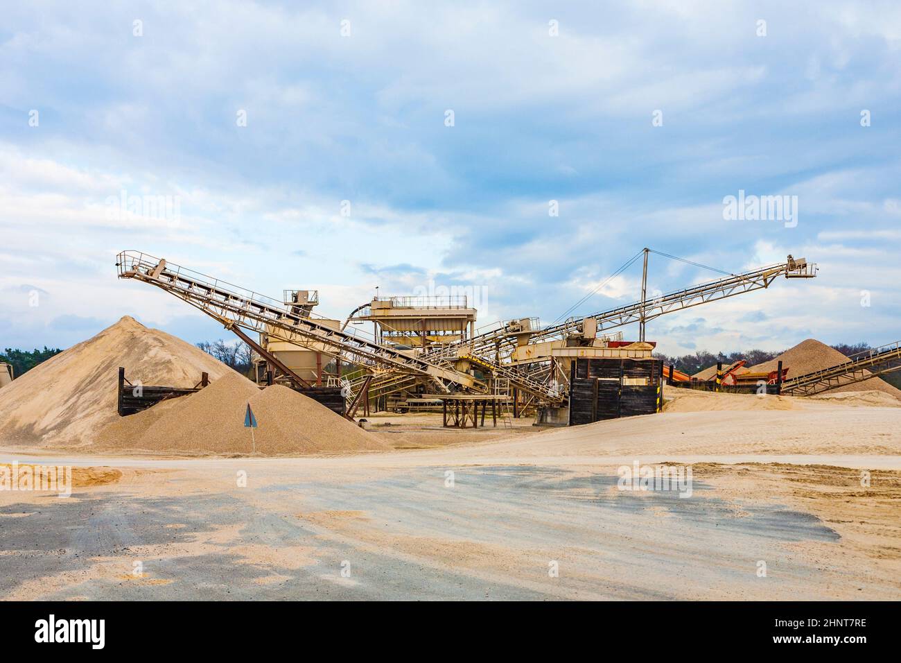Conveyor on site at gravel pit under clouds Stock Photo - Alamy