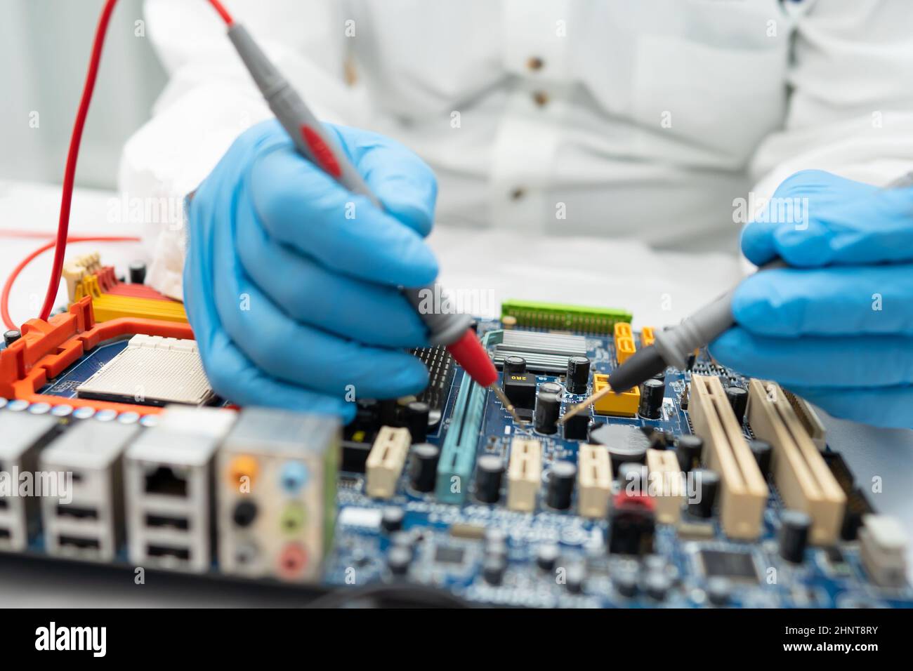 Technician repairing inside of hard disk by soldering iron. Integrated ...