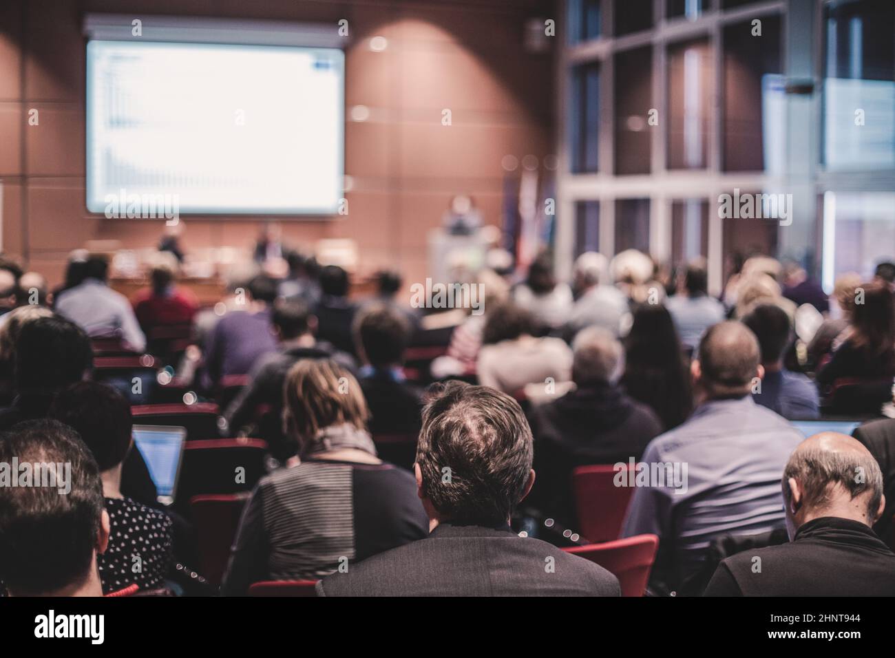 Audience in lecture hall participating at business event Stock Photo ...
