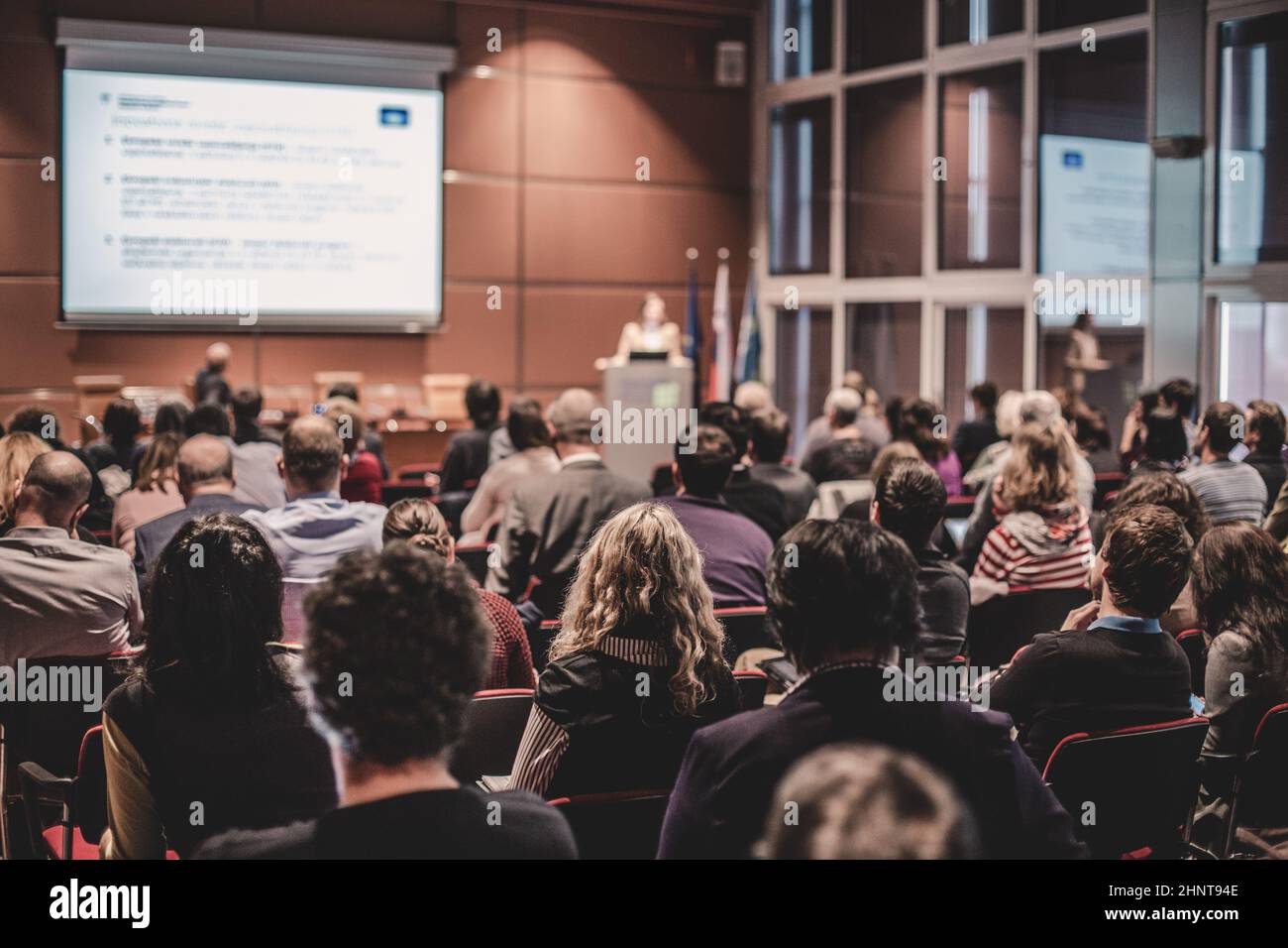 Audience in lecture hall participating at business event Stock Photo ...