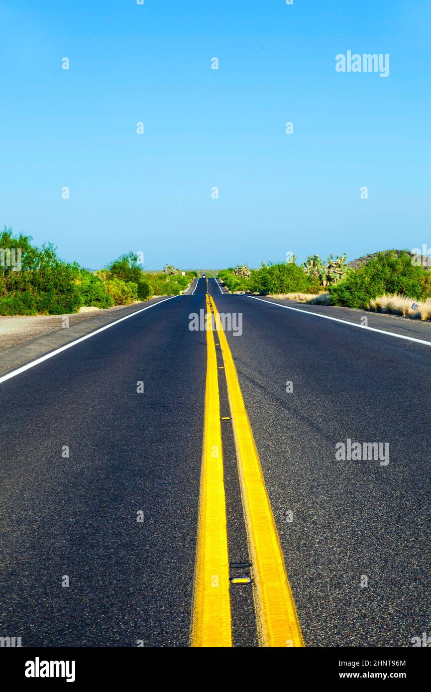 empty freeway in sunset with yellow lines to indicate overtaking ...