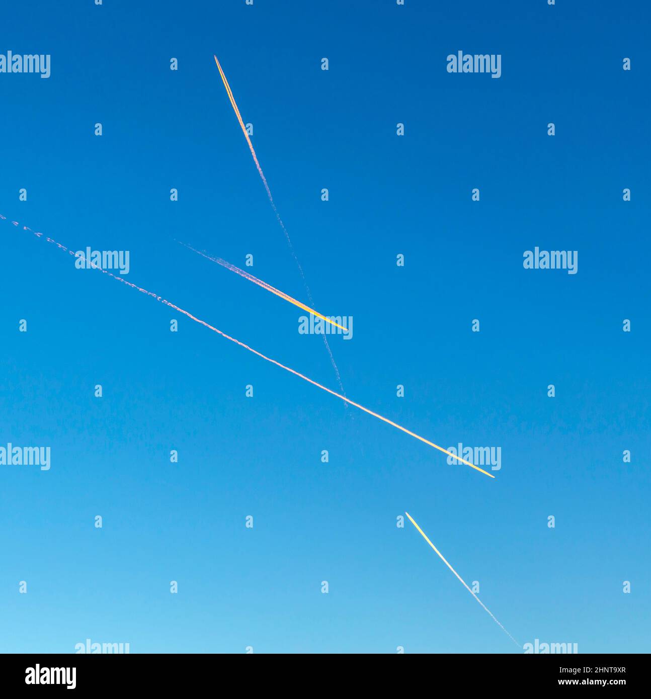 contrail in a blue and orange sky Stock Photo - Alamy