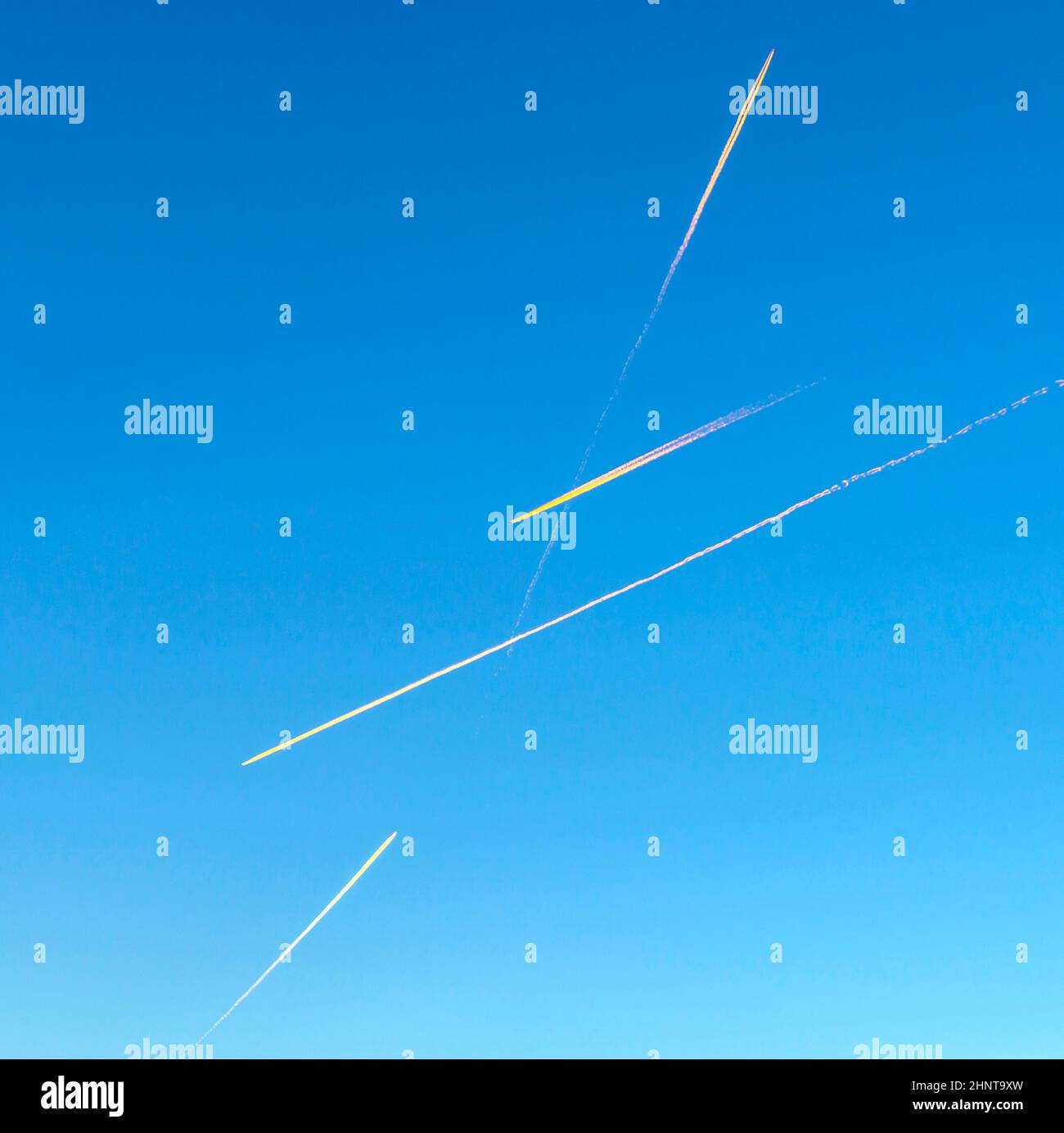 contrail in a blue and orange sky Stock Photo - Alamy