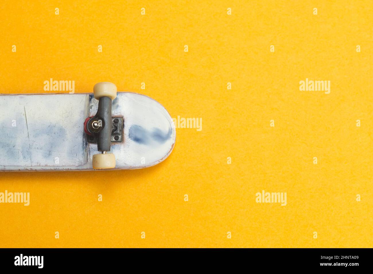 Small skateboard on yellow background. tiny skate for fingers ...