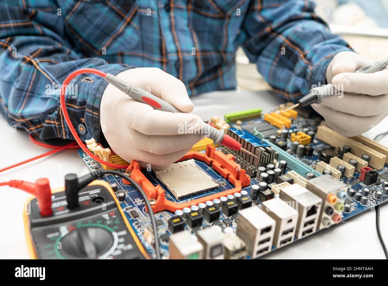technician repairing inside of hard disk by soldering iron. Integrated ...