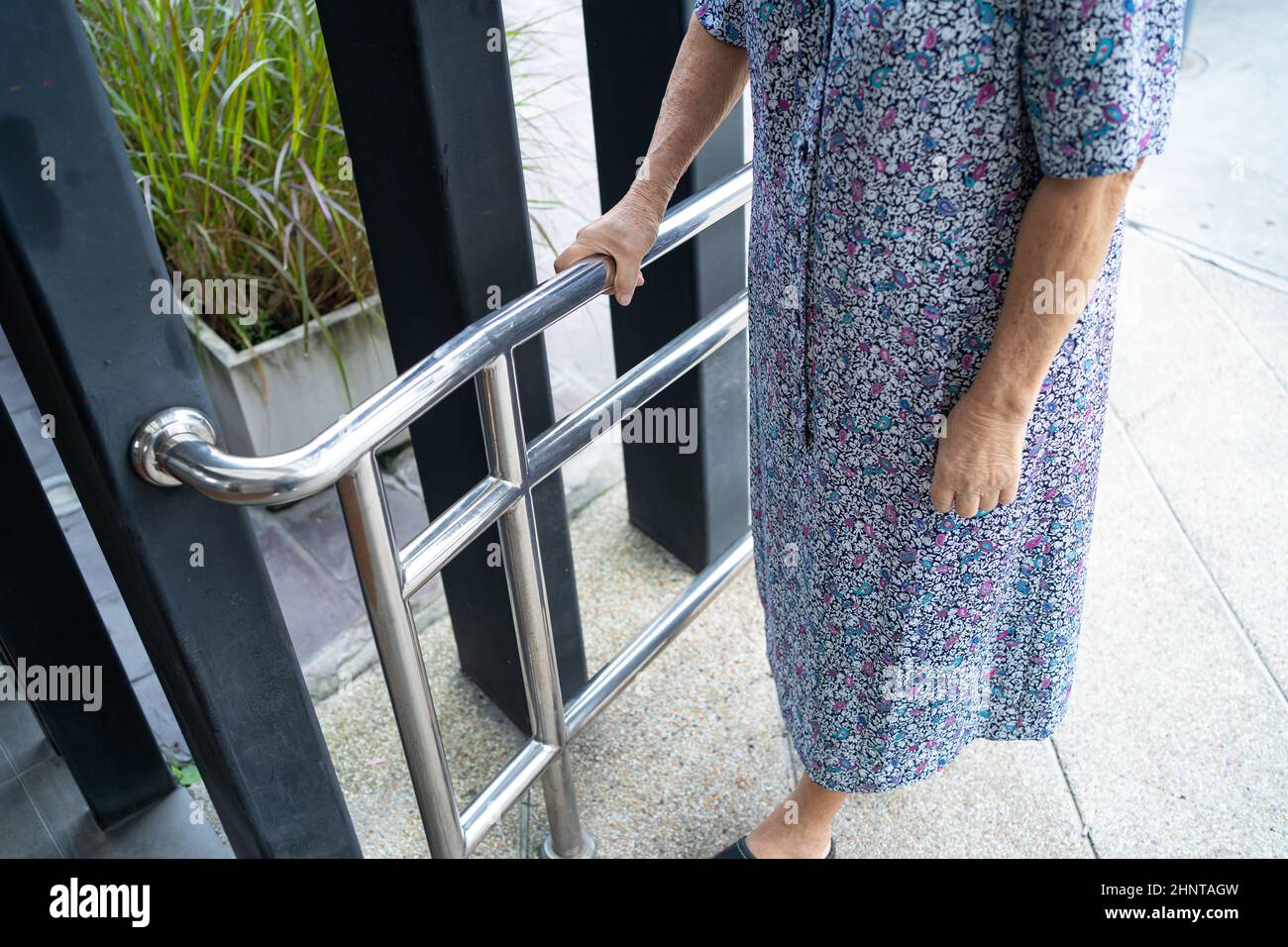 Asian senior or elderly old lady woman patient use slope walkway handle ...