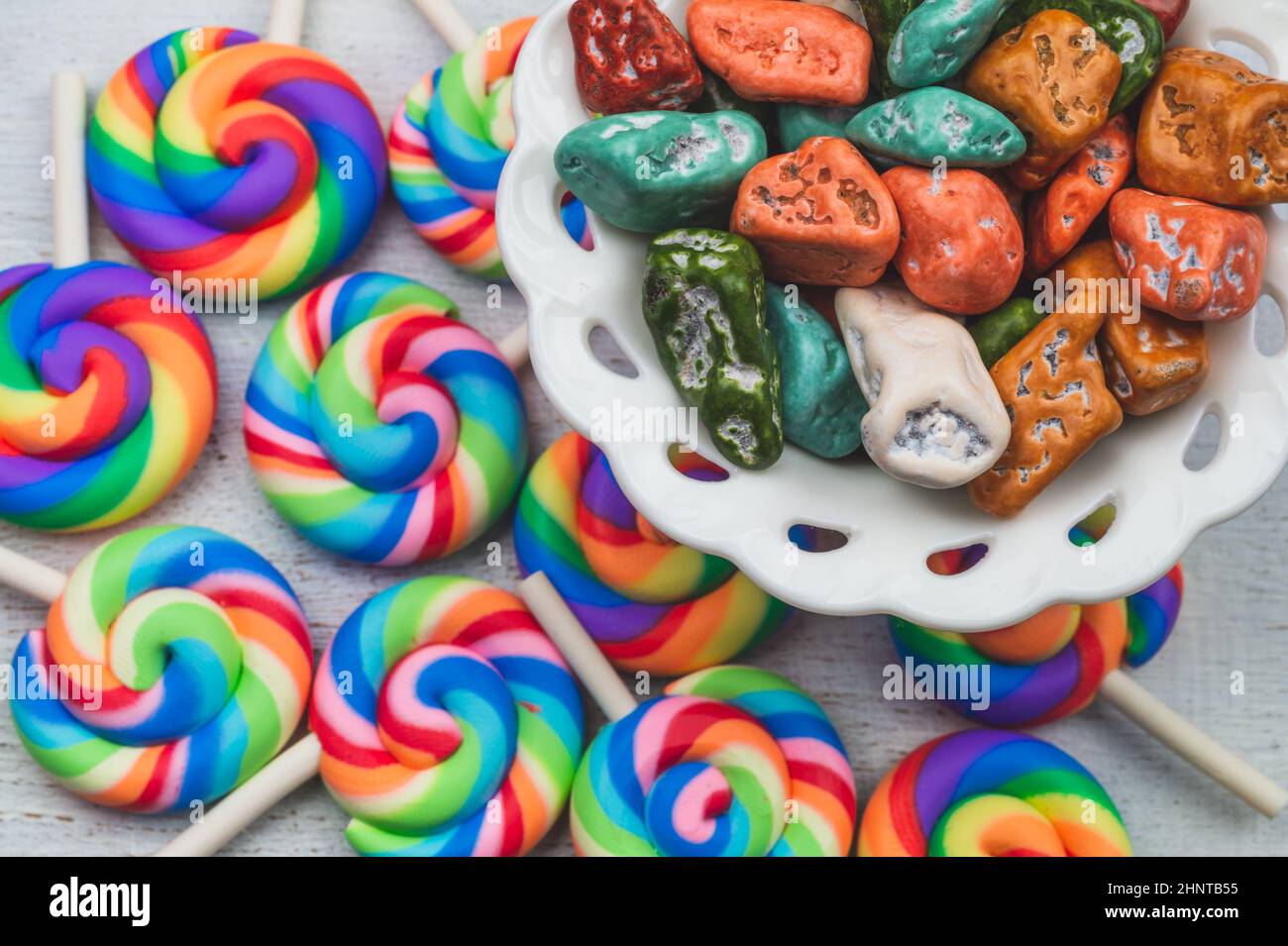 Candy pebbles in a bowl and lollipops. spiral candies and sweets in the ...