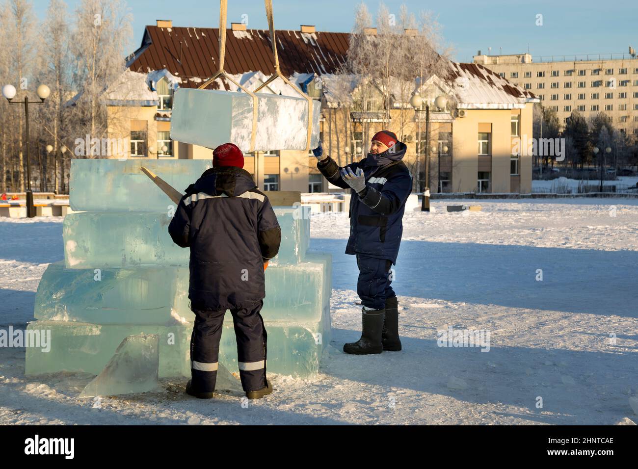 Two assembly workers stacking ice slabs on a construction site Stock ...