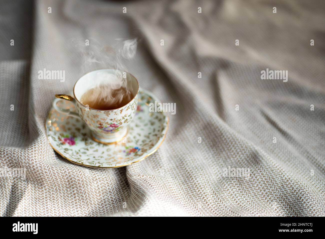 Porcelain tea pot and cup of hot tea on the table, antique traditional ...