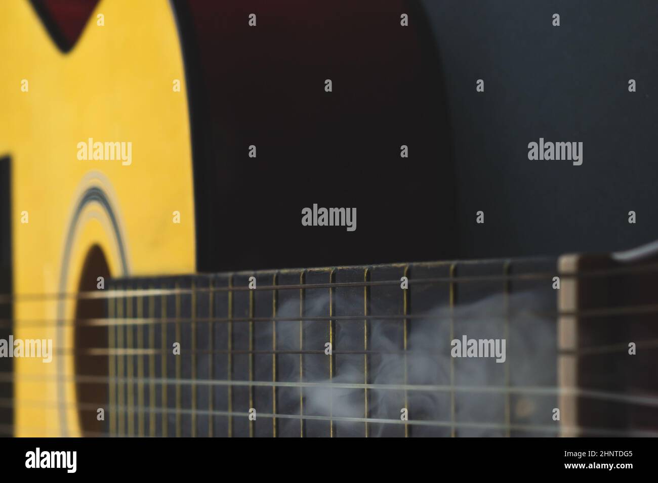 Acoustic guitar in smoke close up. musical instrument. strings on the ...