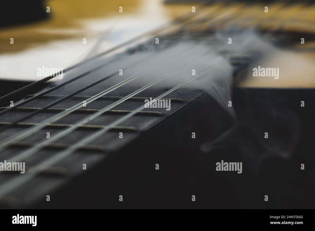 Acoustic guitar in smoke close up. musical instrument. strings on the ...