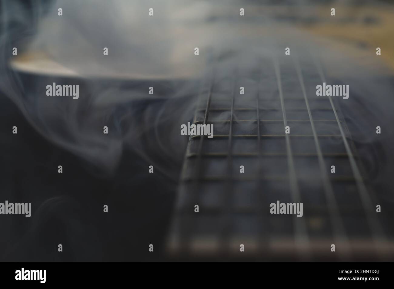 Acoustic guitar in smoke close up. musical instrument. strings on the ...