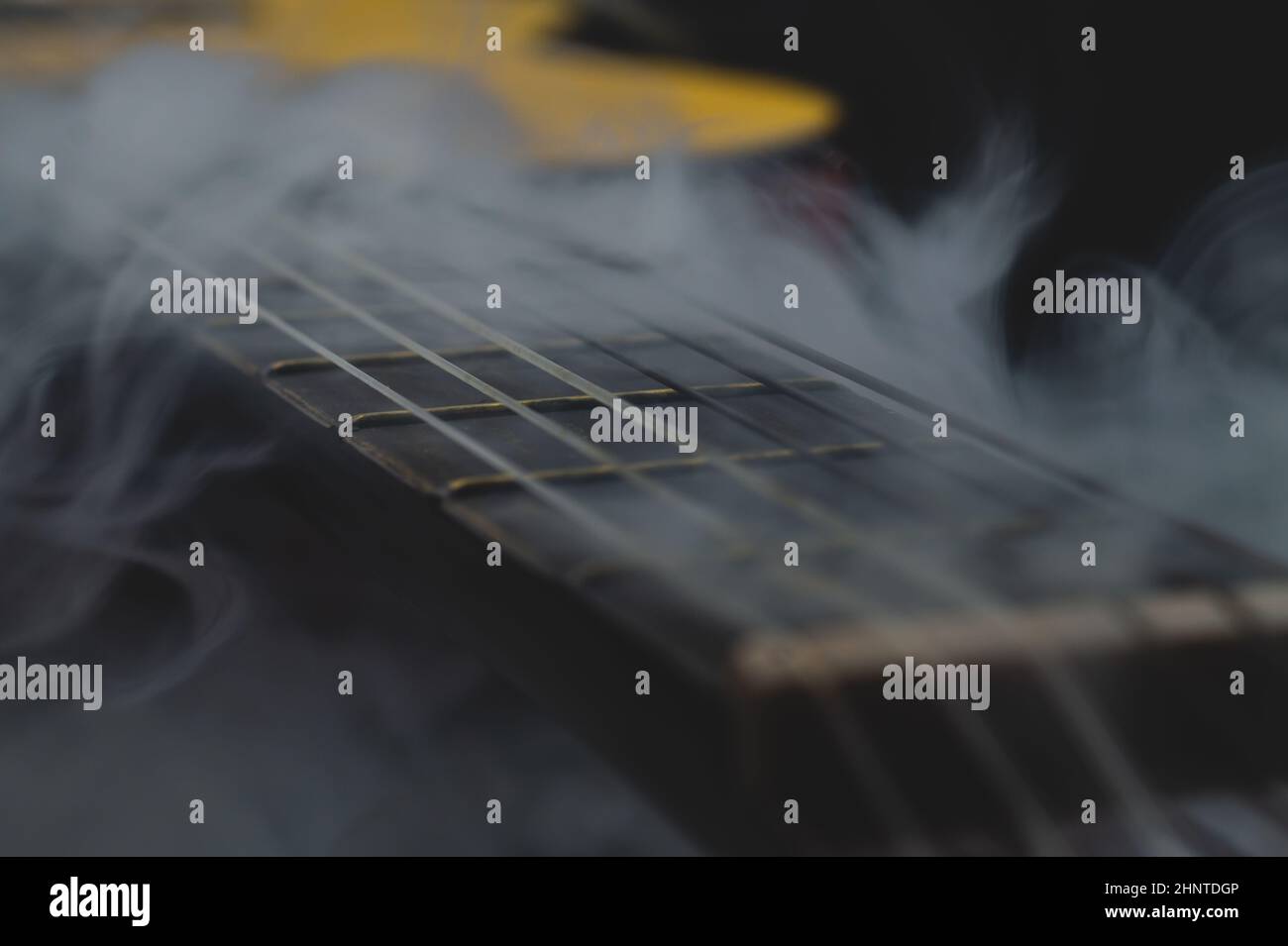 Acoustic guitar in smoke close up. musical instrument. strings on the ...