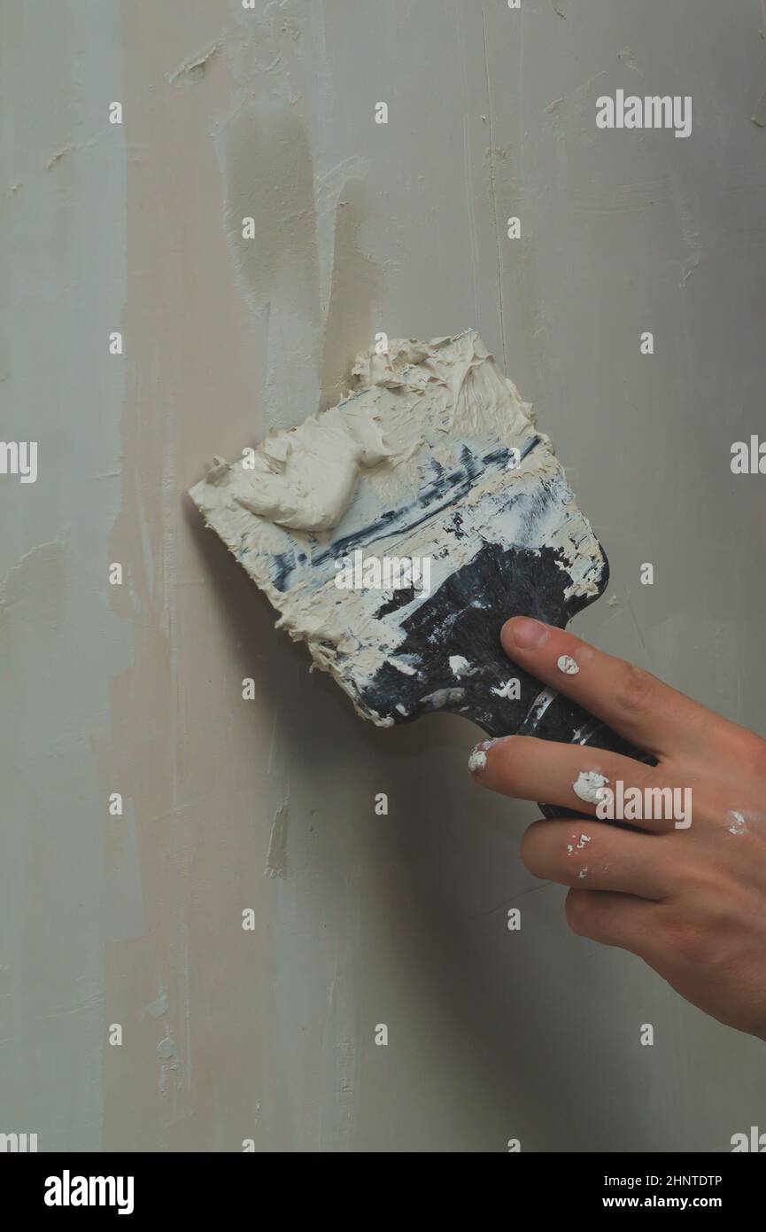 Hand holds construction spatula with putty. trowel with spackling ...