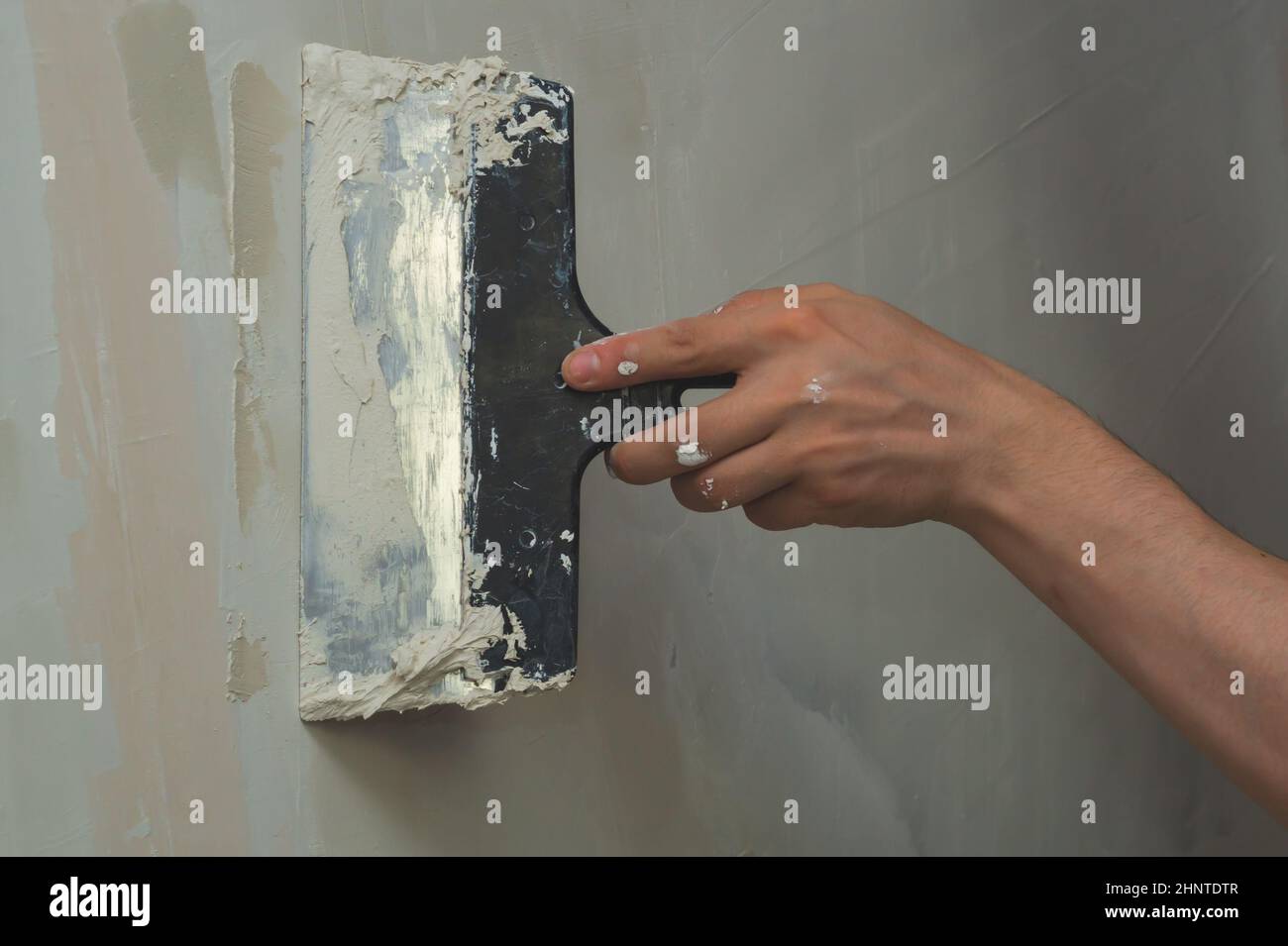 Hand holds construction spatula with putty. trowel with spackling ...