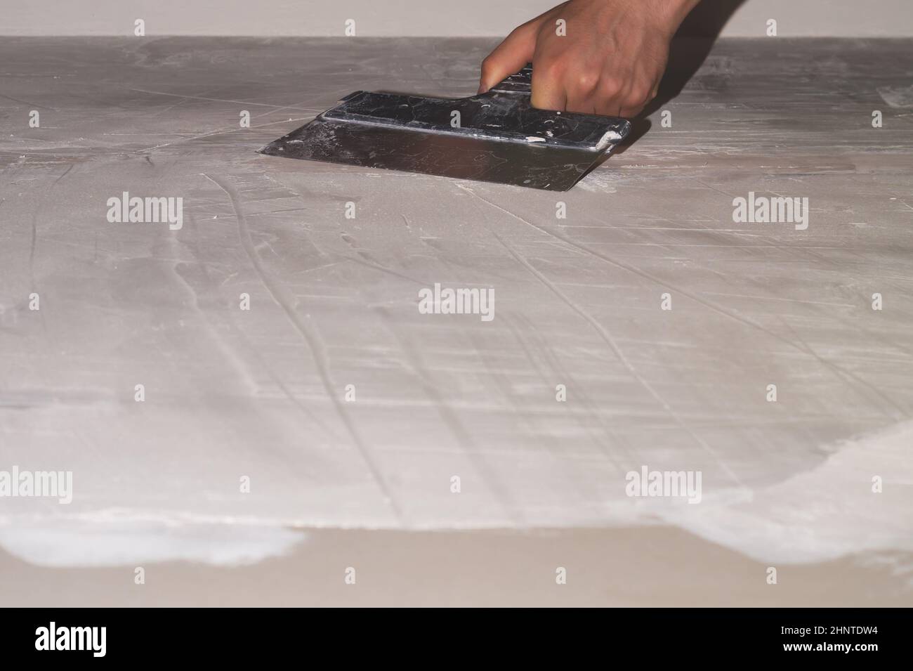 Hand holds construction spatula with putty. trowel with spackling ...