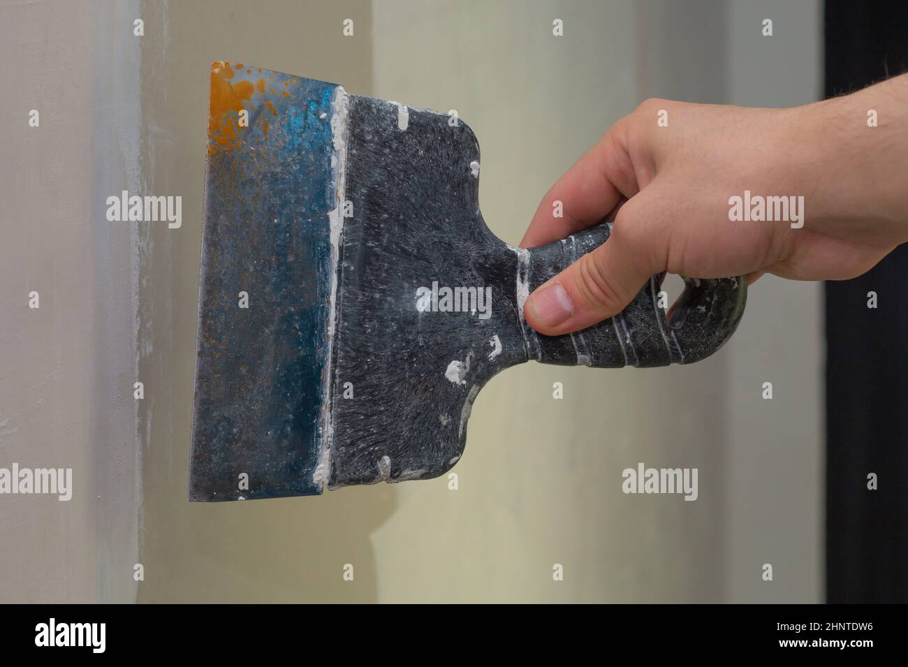 Hand holds construction spatula with putty. trowel with spackling ...