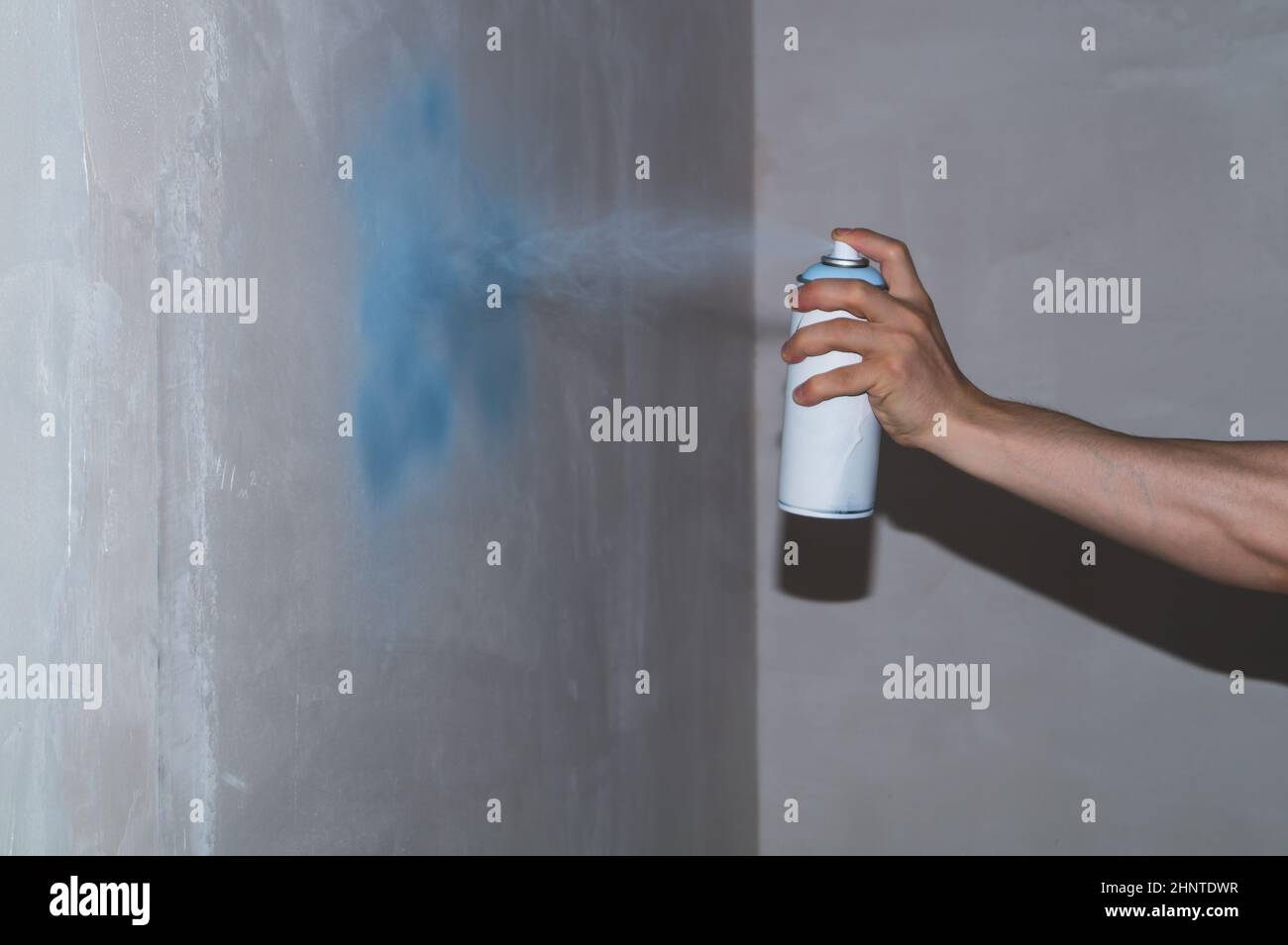 Spray can in the hand. spraying paint on the wall. painting process ...