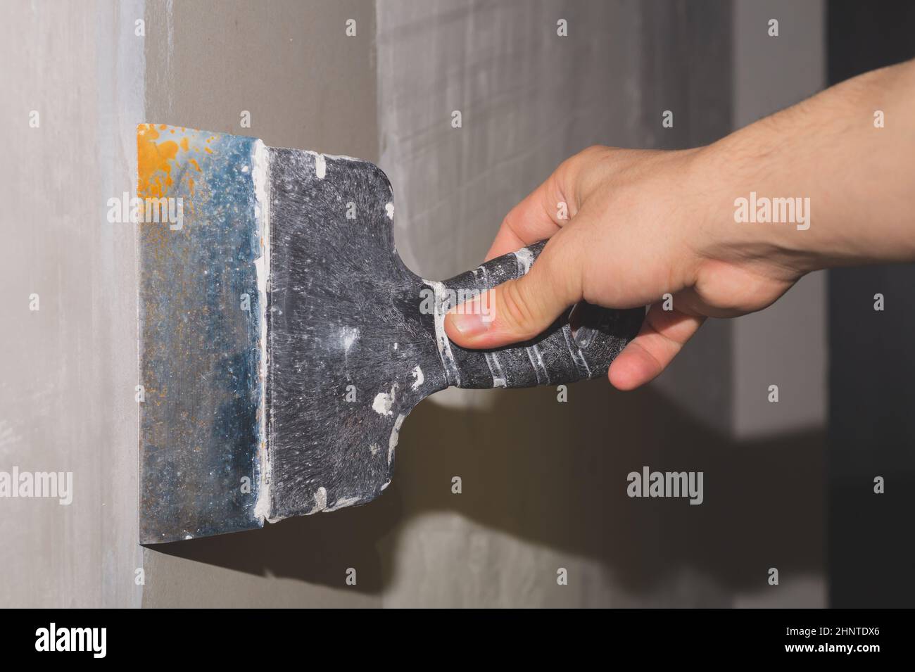 Hand holds construction spatula with putty. trowel with spackling ...