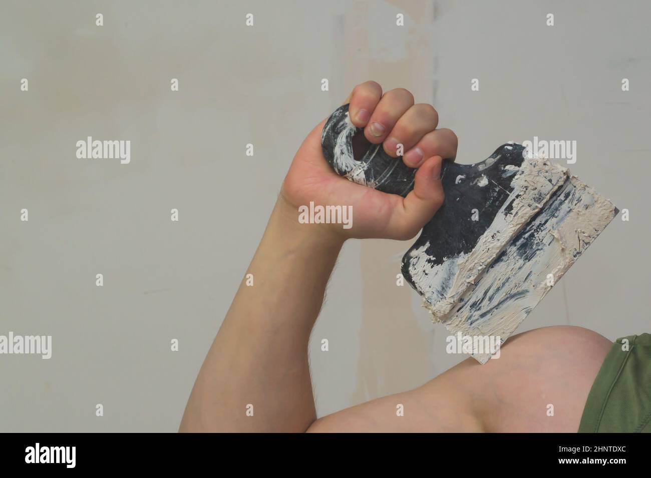 Hand holds construction spatula with putty. trowel with spackling ...